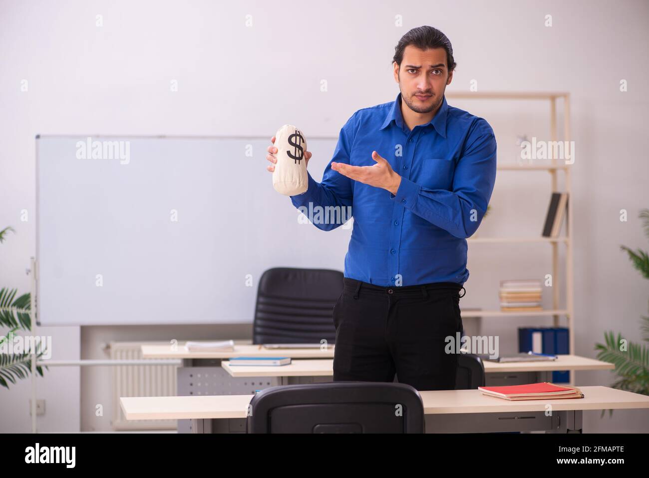 Young teacher in remuneration concept Stock Photo - Alamy