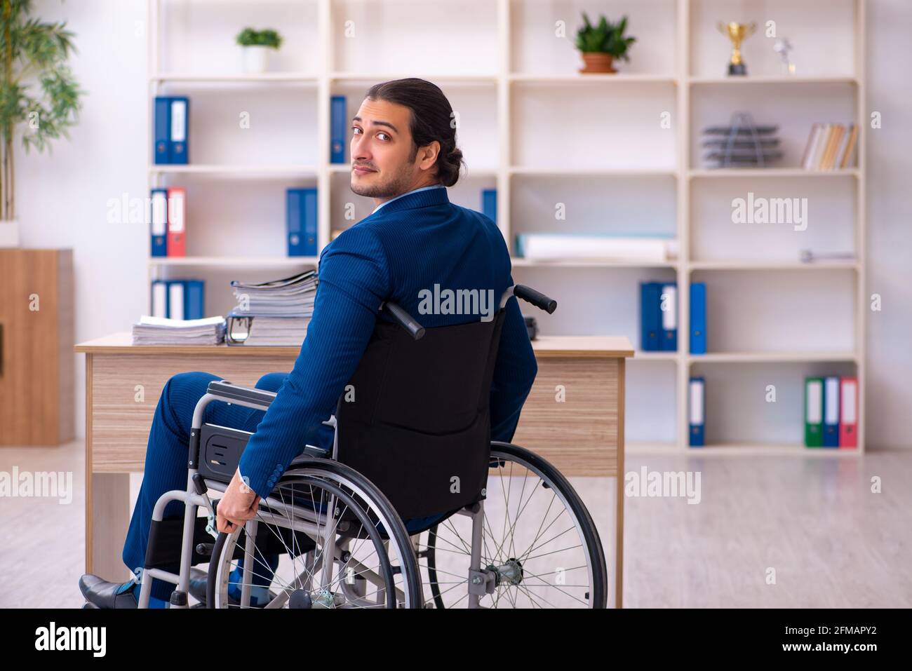 Young male disabled employee working in the office Stock Photo - Alamy