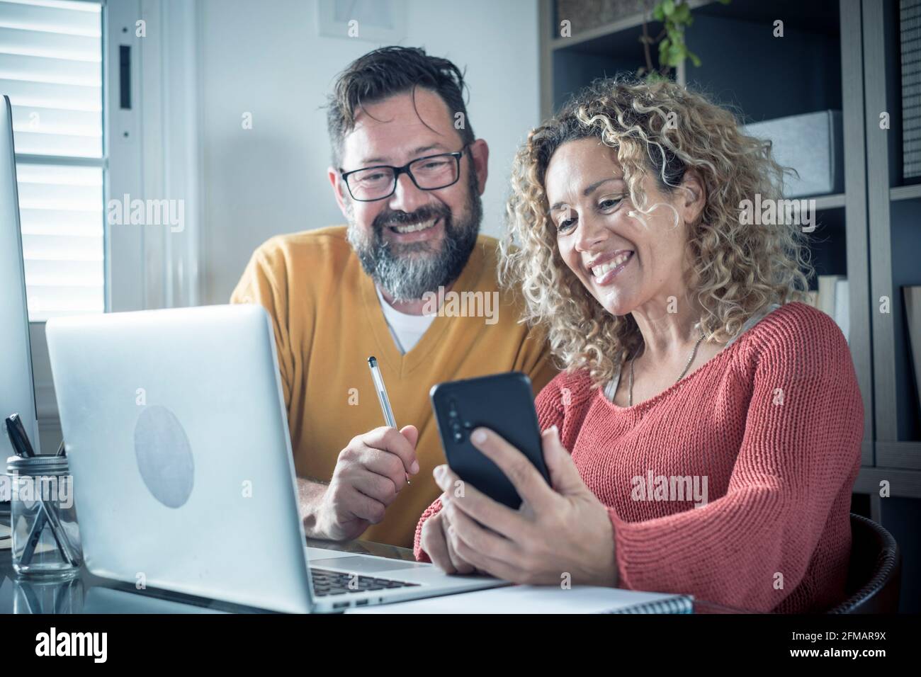 Man and woman team work together in couple at home with technology and ...