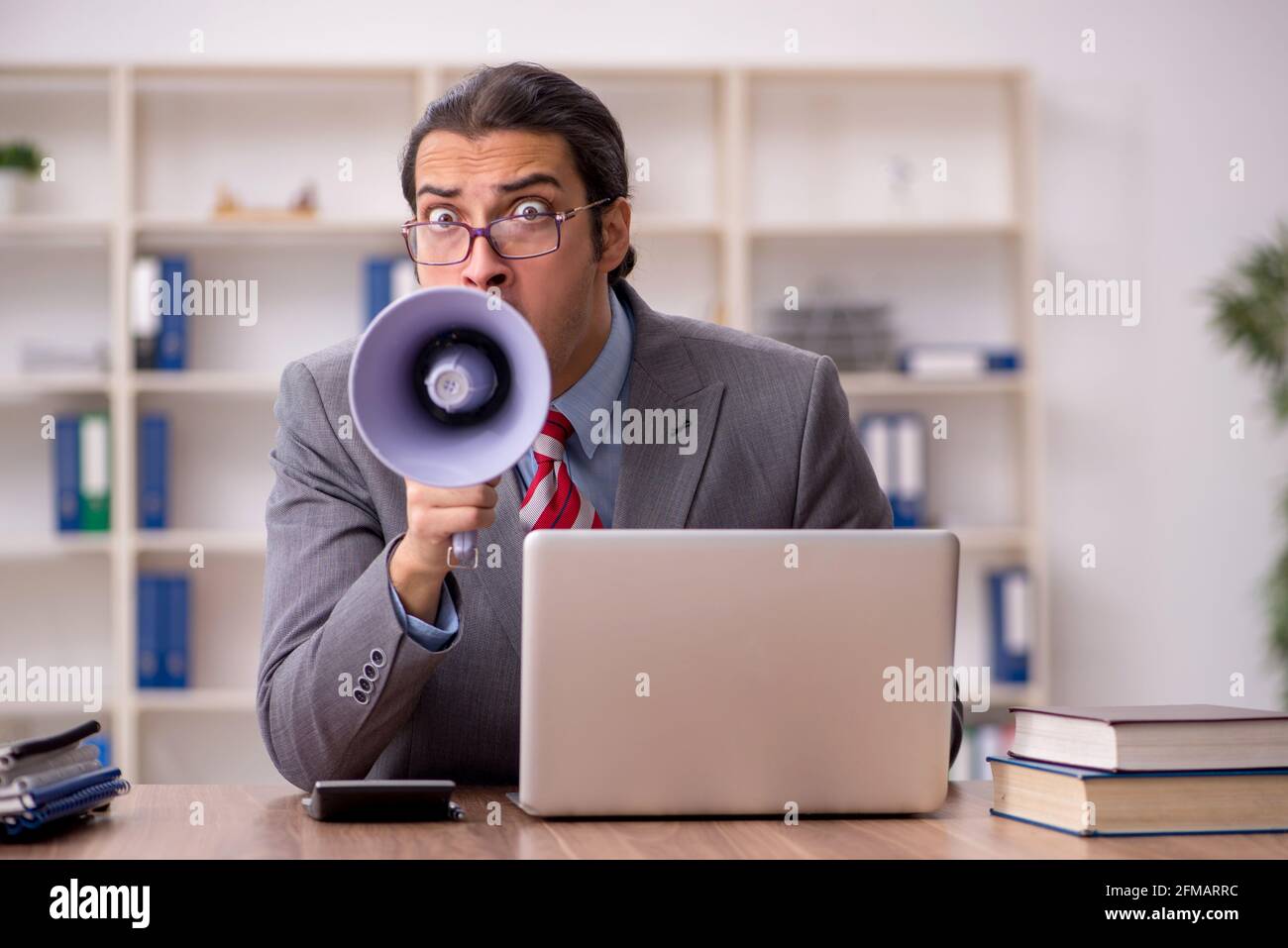 Young businessman employee holding megaphone Stock Photo - Alamy