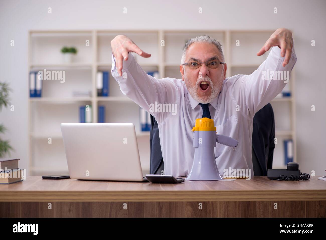Old businessman employee holding megaphone at workplace Stock Photo - Alamy