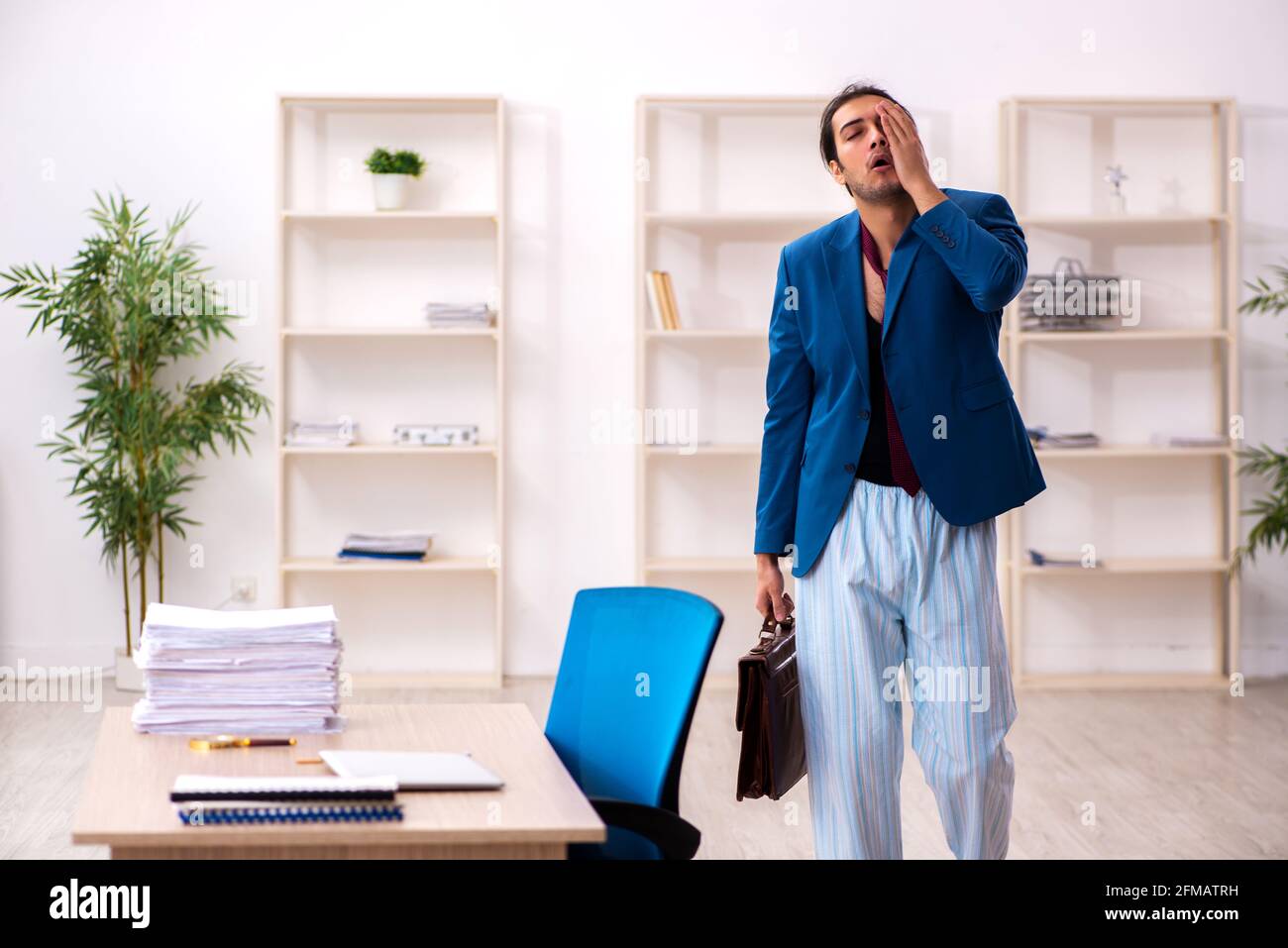 Young businessman employee in oversleeping concept Stock Photo - Alamy