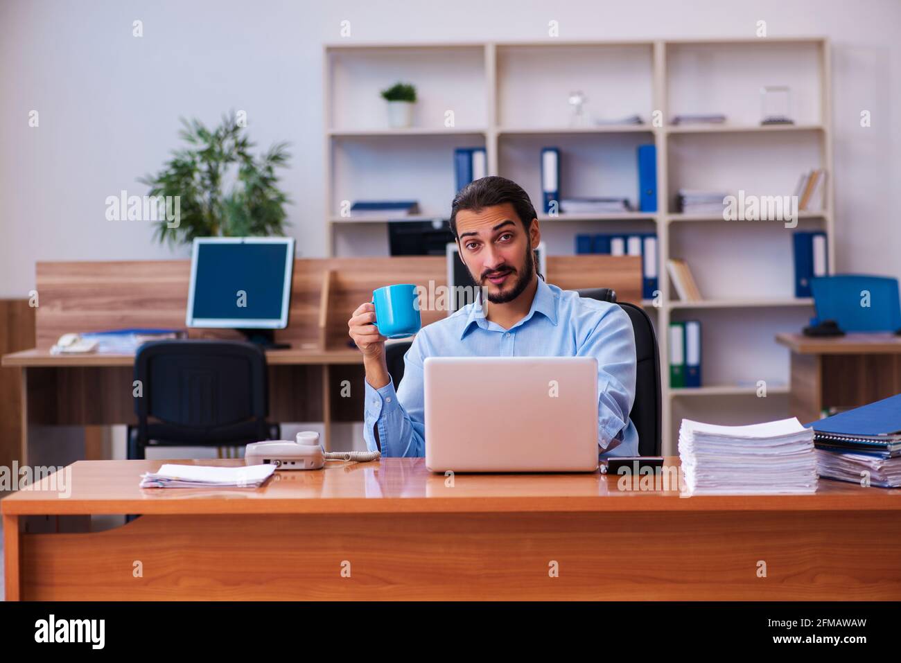 Young employee drinking tea during break Stock Photo - Alamy