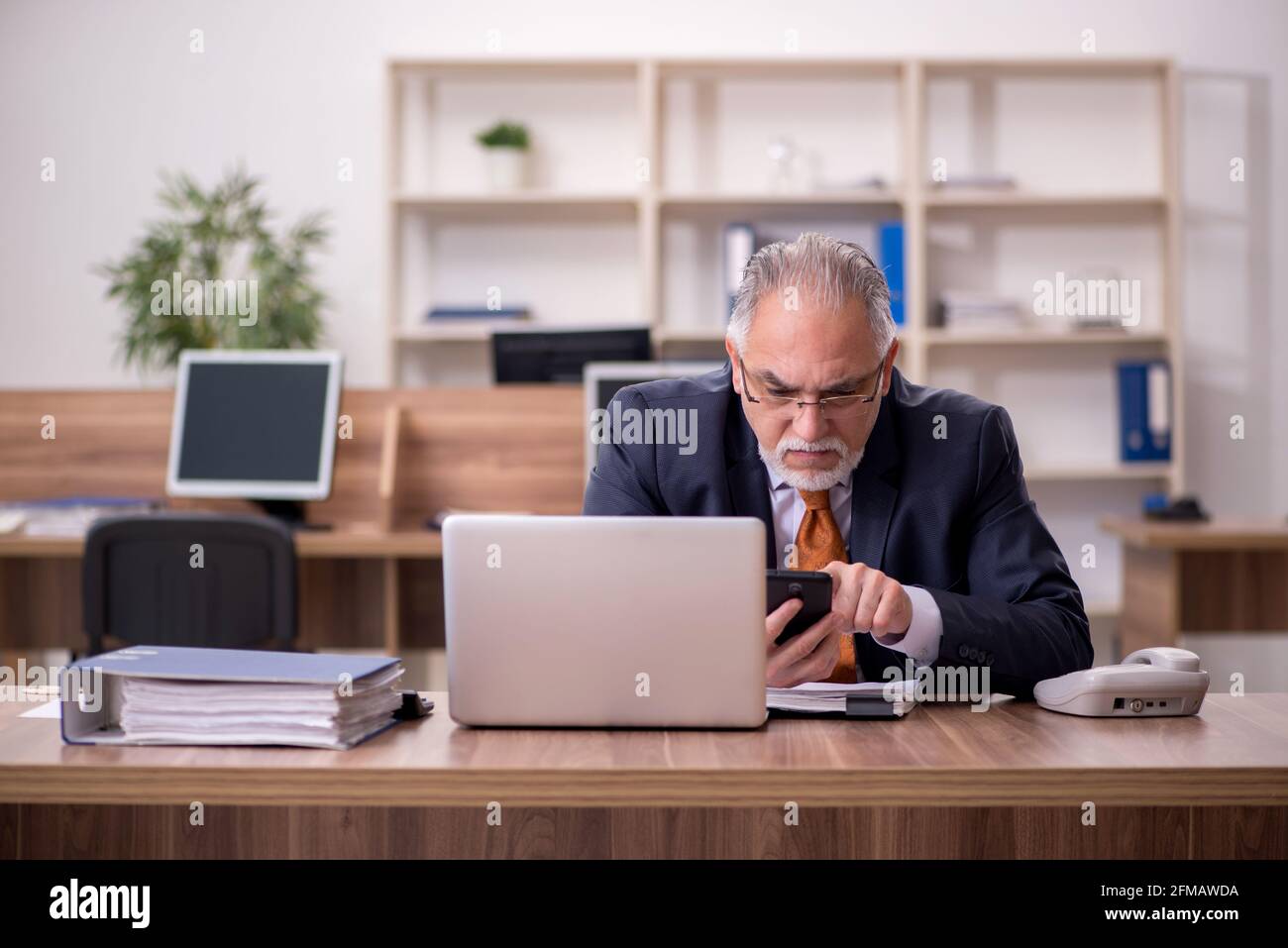 Old employee working in the office Stock Photo - Alamy