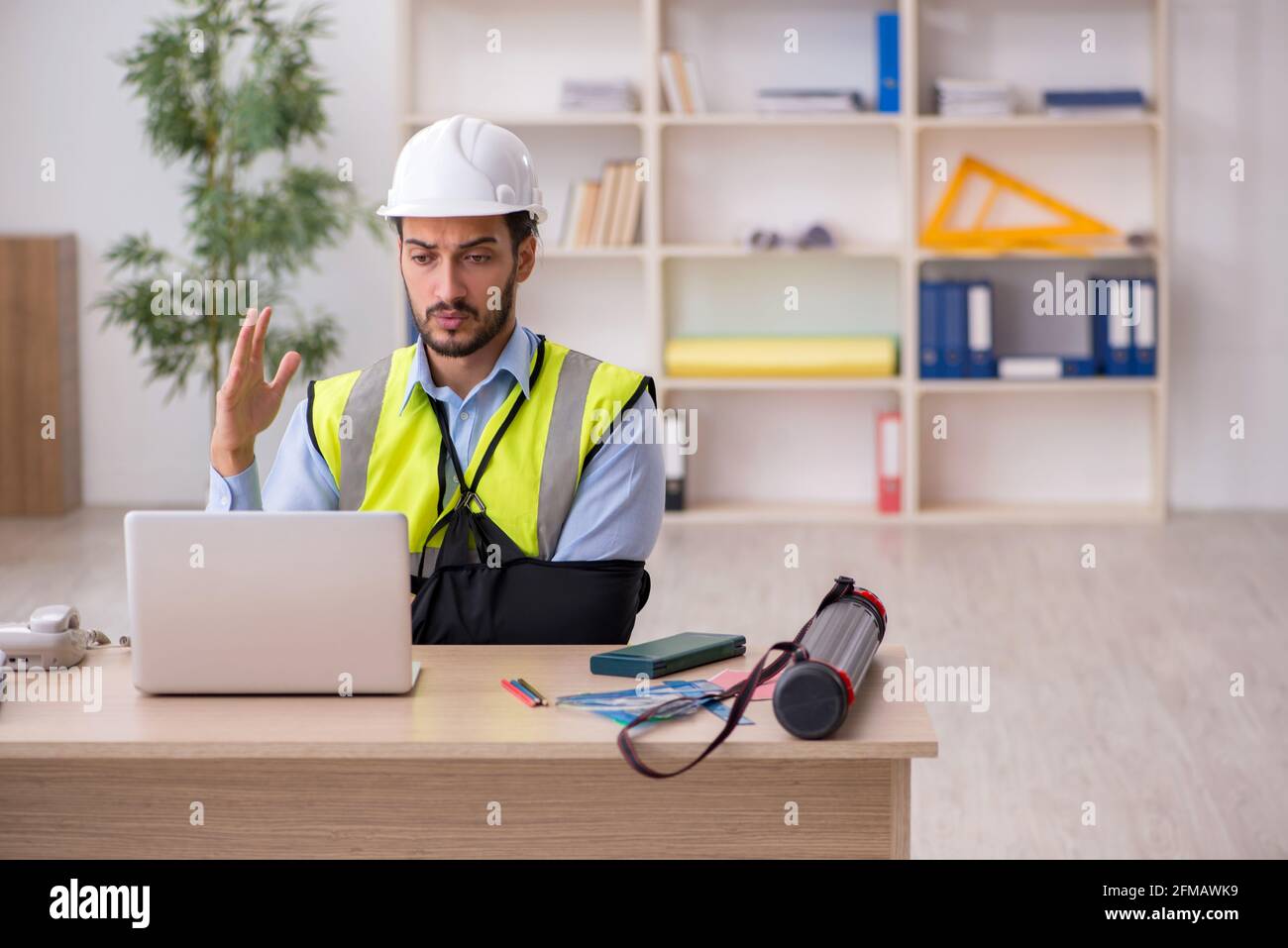 Young arm injured architect working in the office Stock Photo - Alamy