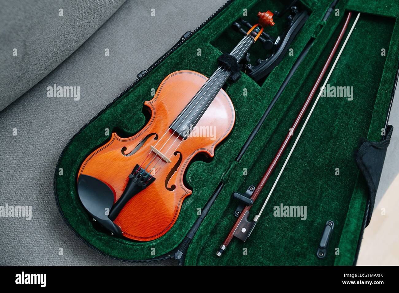 Violin, bow and support system gently placed in a case draped in yellow ...