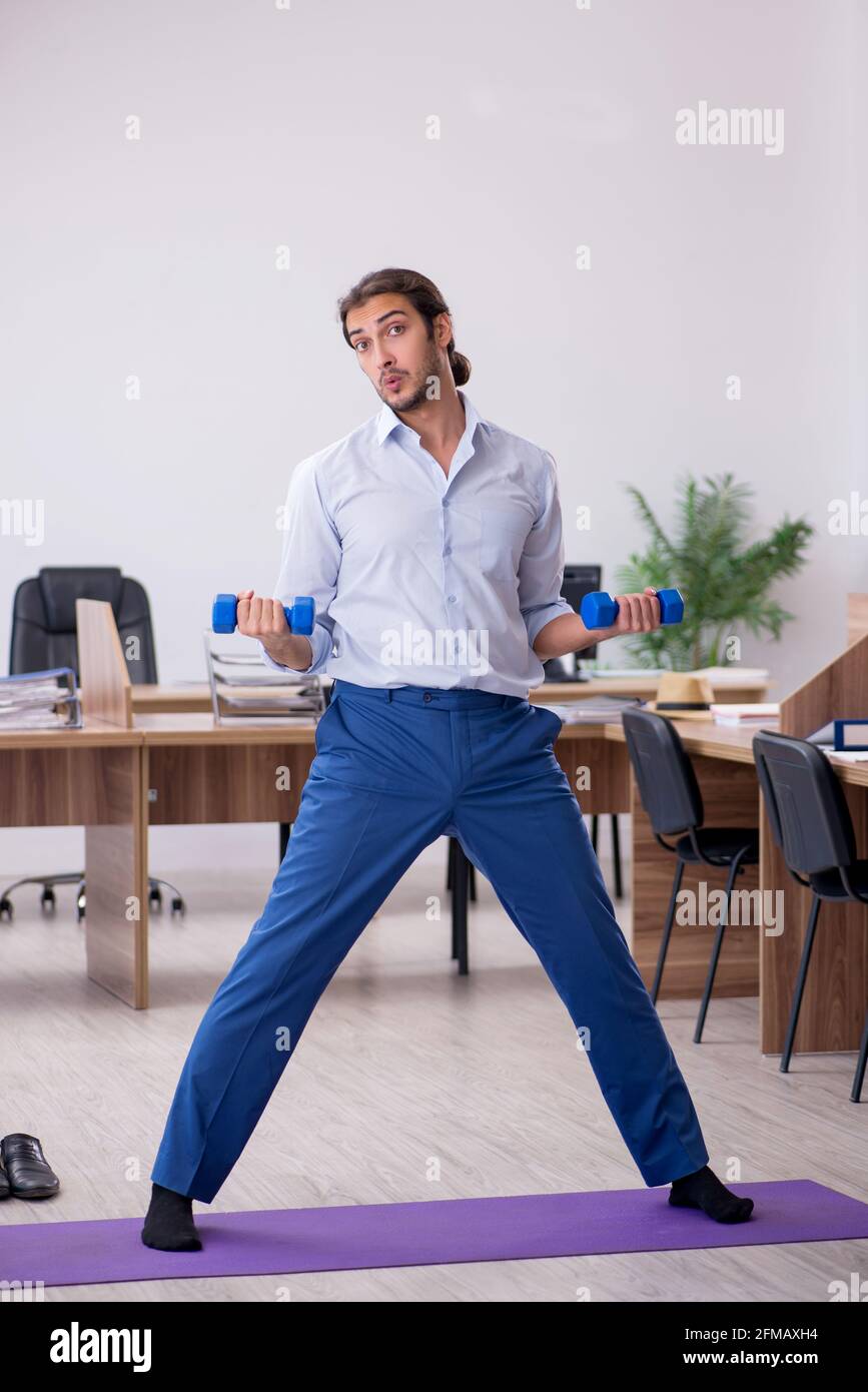 Young employee doing sport exercises during break Stock Photo - Alamy
