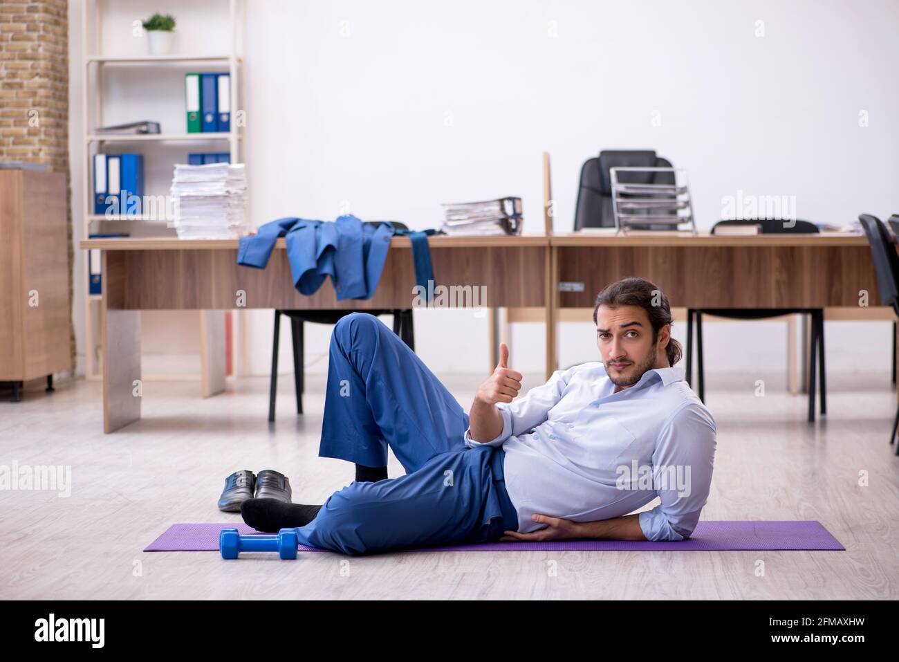 Young employee doing sport exercises during break Stock Photo - Alamy