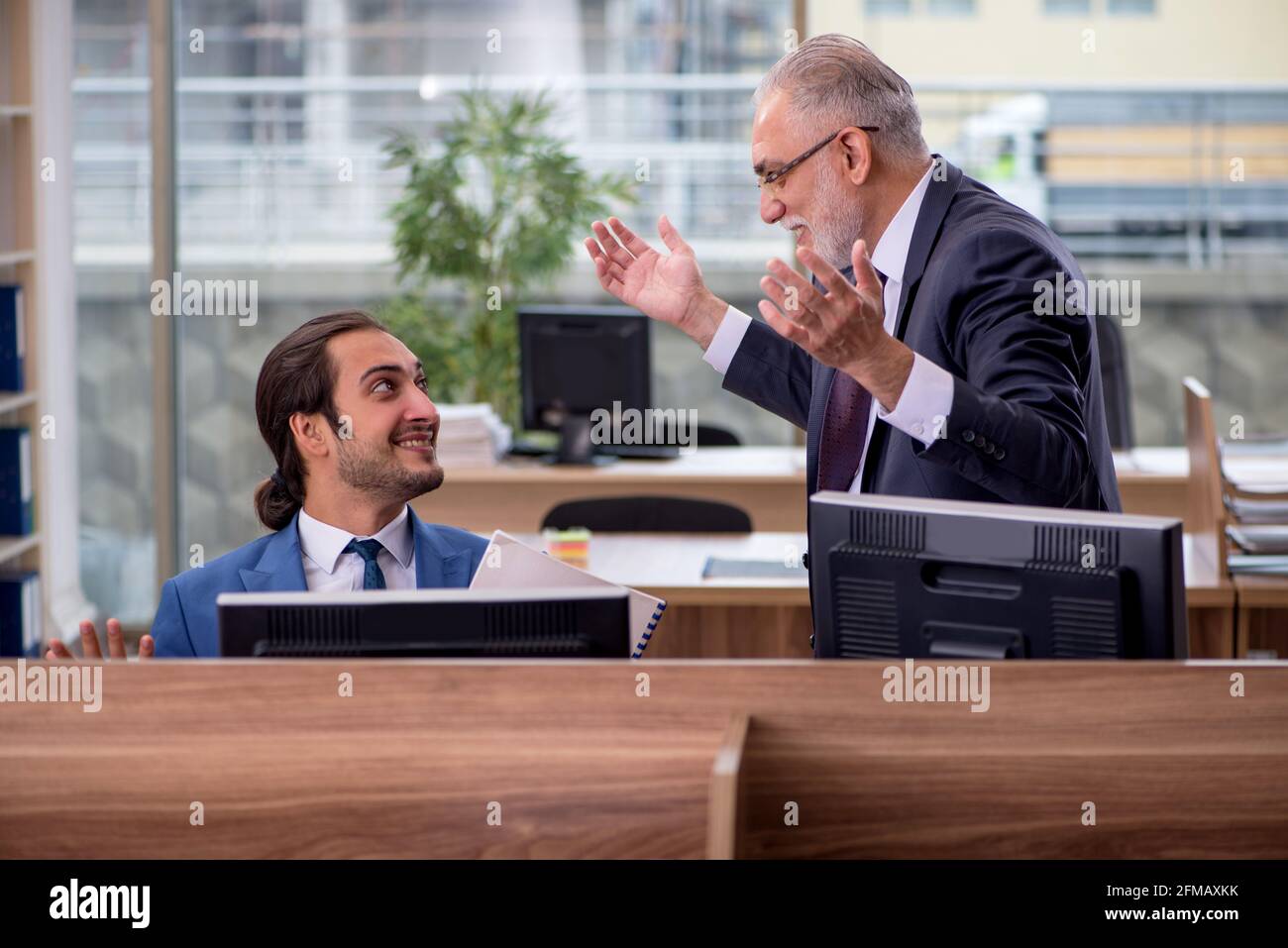 Two businessmen employees sitting in the office Stock Photo - Alamy