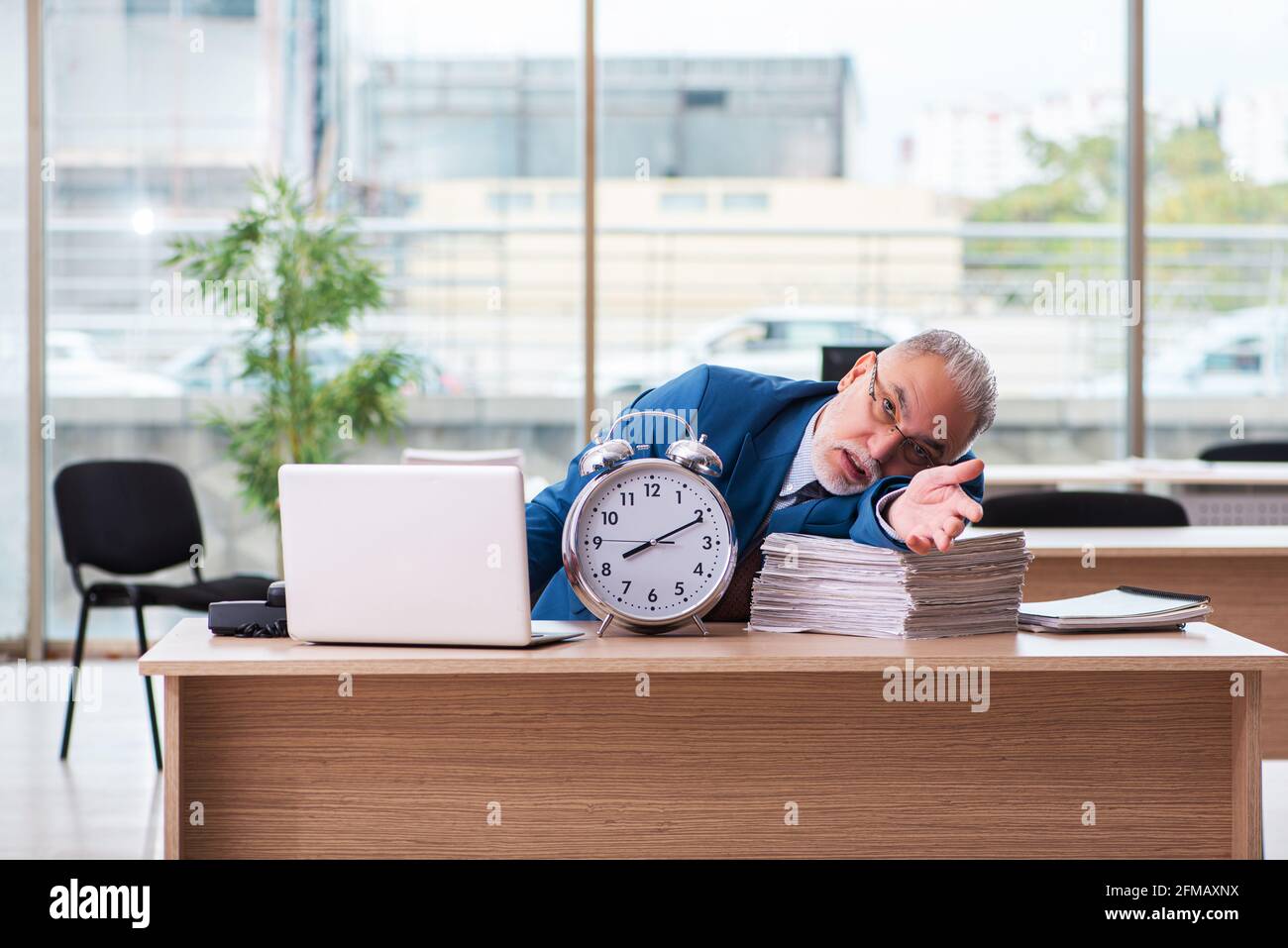 Old boss employee in time management concept Stock Photo - Alamy