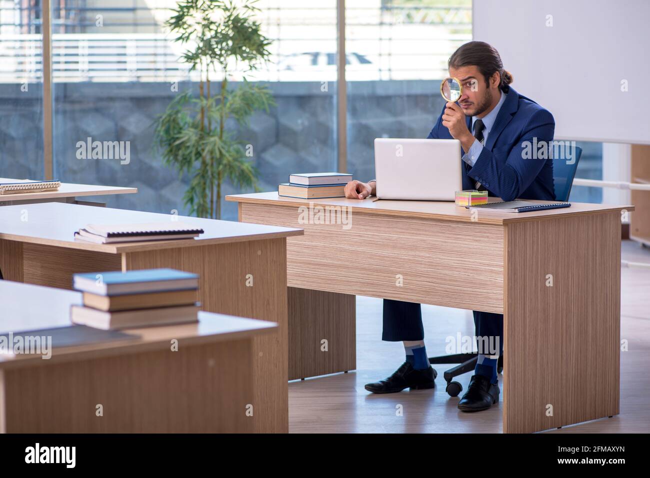 Young teacher in suit in the classroom Stock Photo - Alamy
