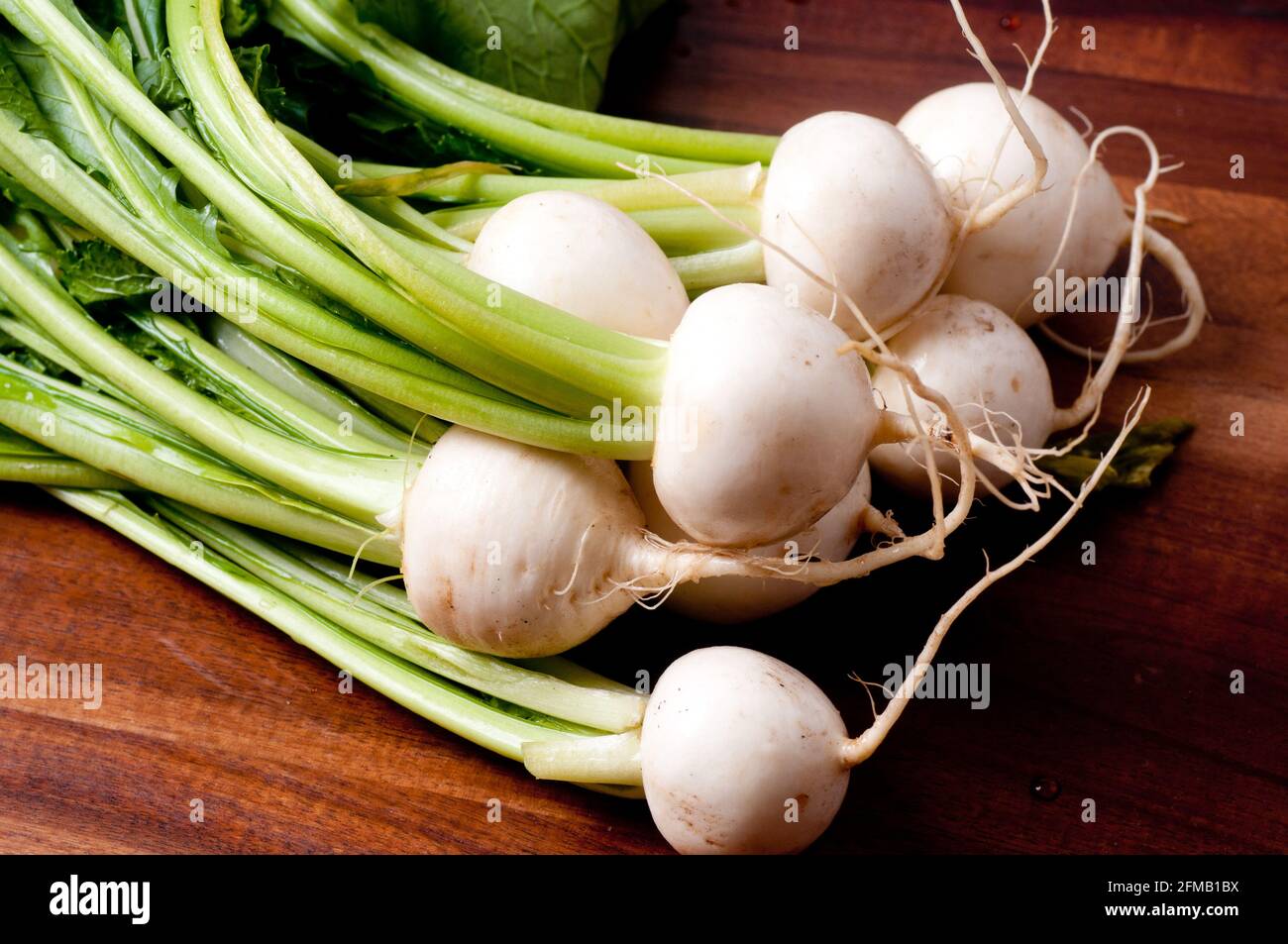 Closeup shot of a pile of white radishes isolated on the wooden table ...