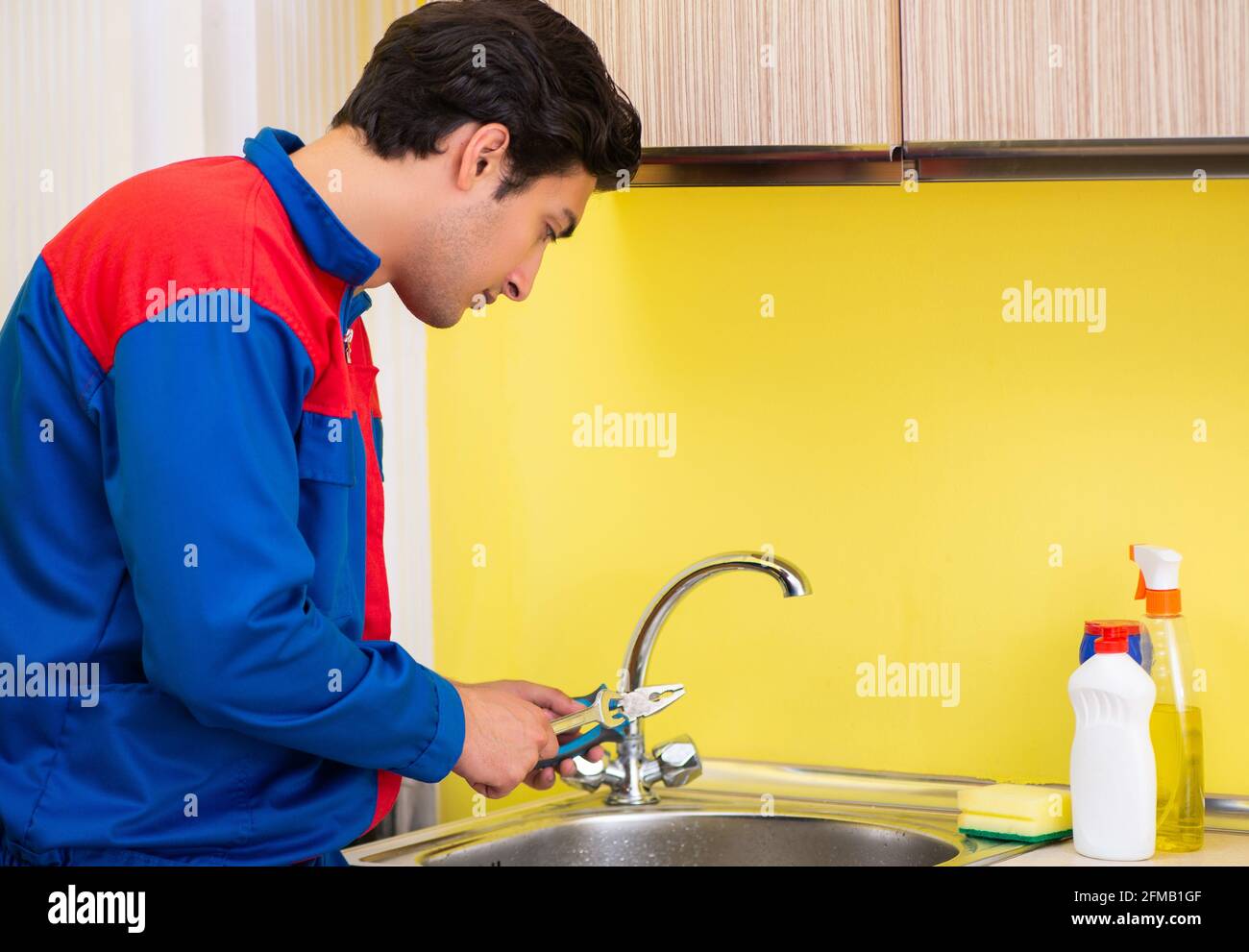 The plumber repairing tap at kitchen Stock Photo - Alamy