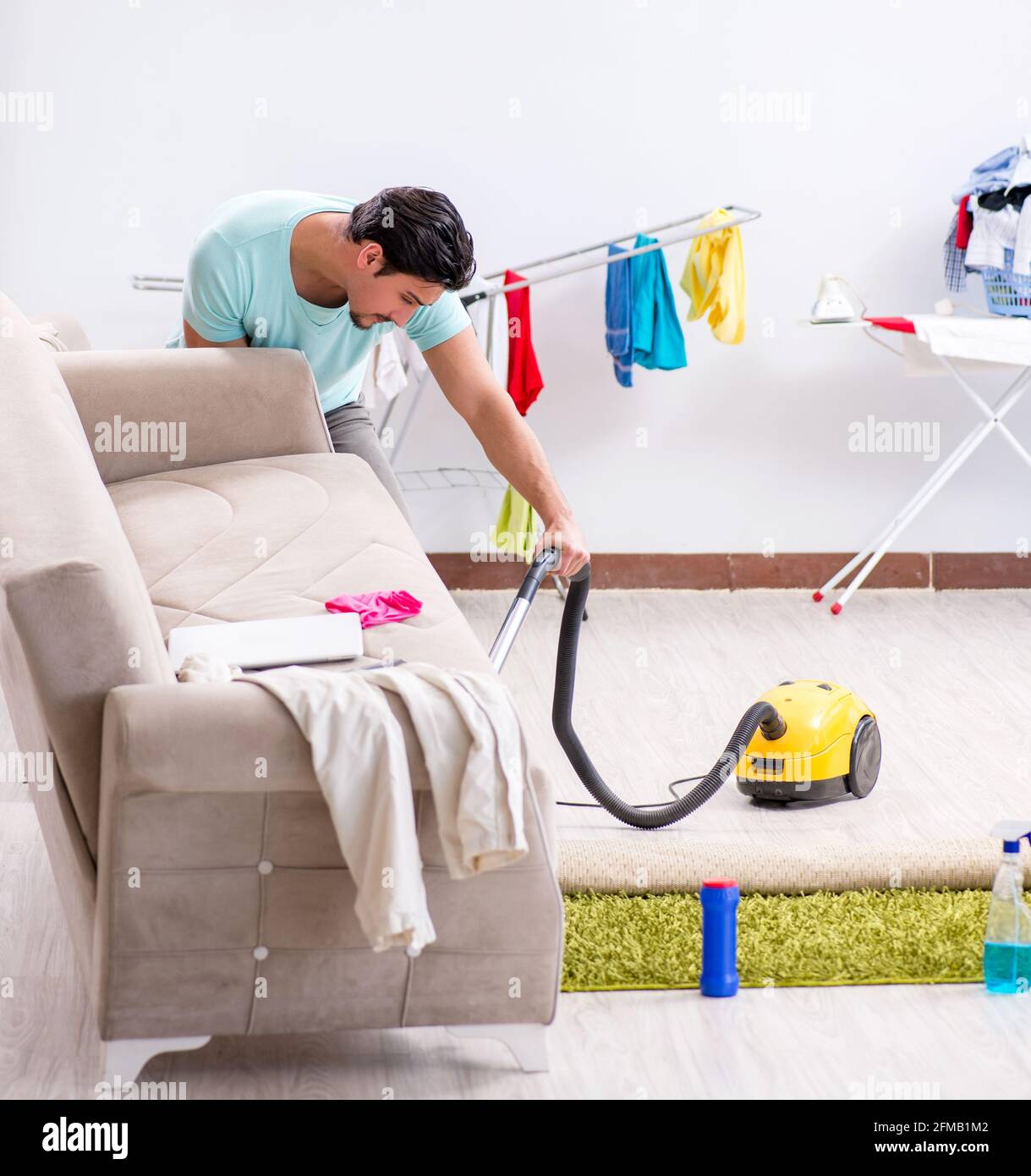 The young man husband doing vacuuming at home Stock Photo - Alamy
