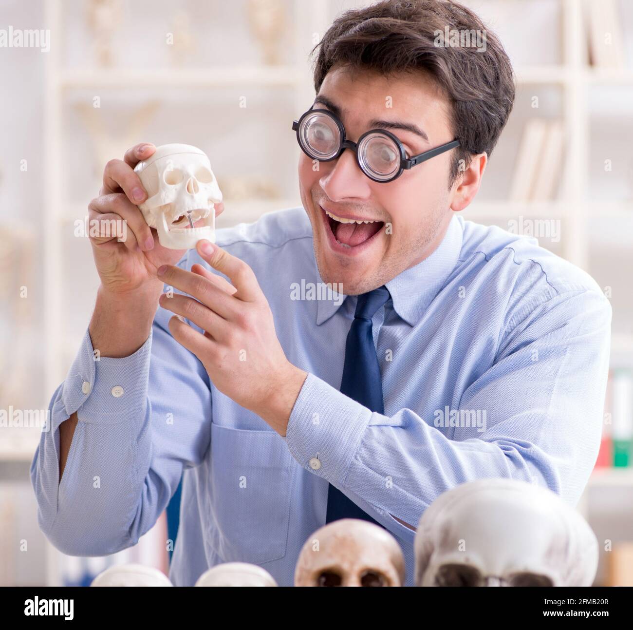 The funny crazy professor studying human skeleton Stock Photo - Alamy