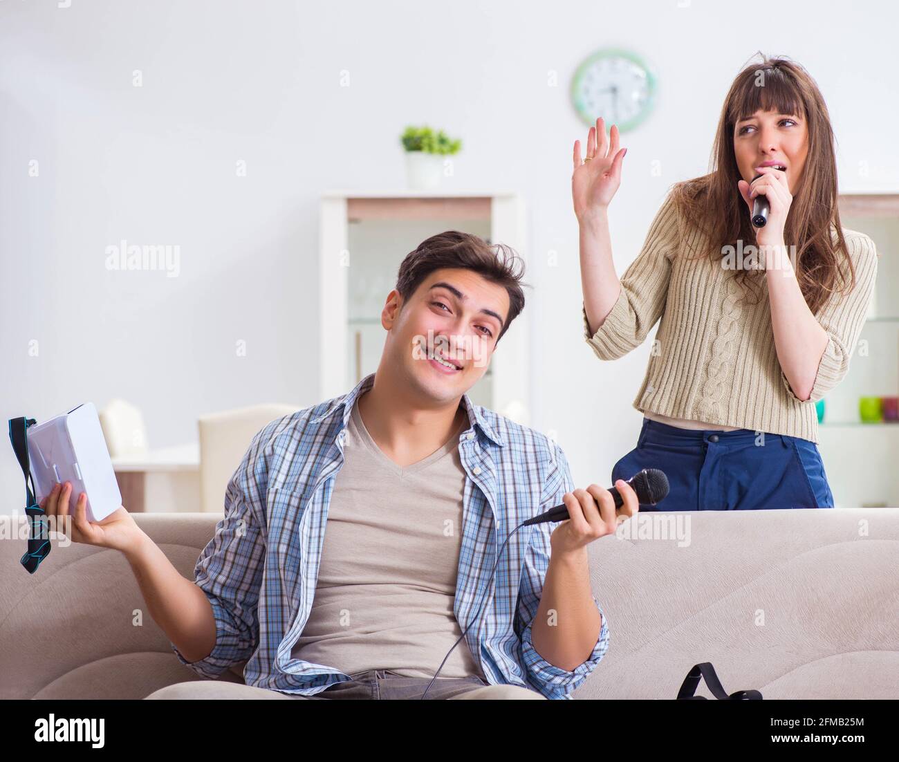 The pair singing karaoke with virtual reality glasses Stock Photo - Alamy