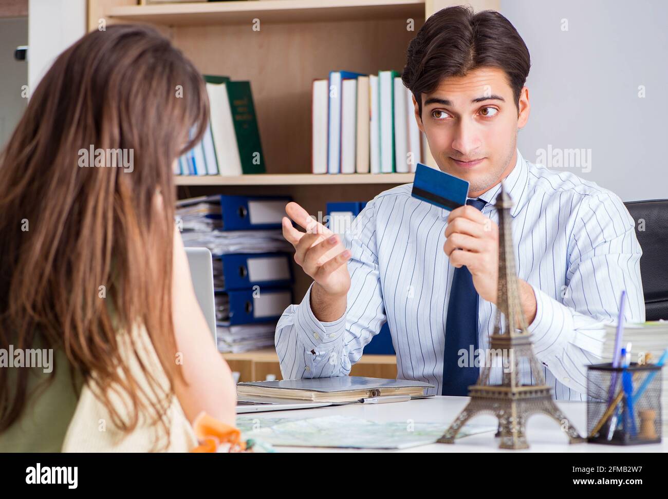 The customer visiting travel agency and talking to agent Stock Photo ...