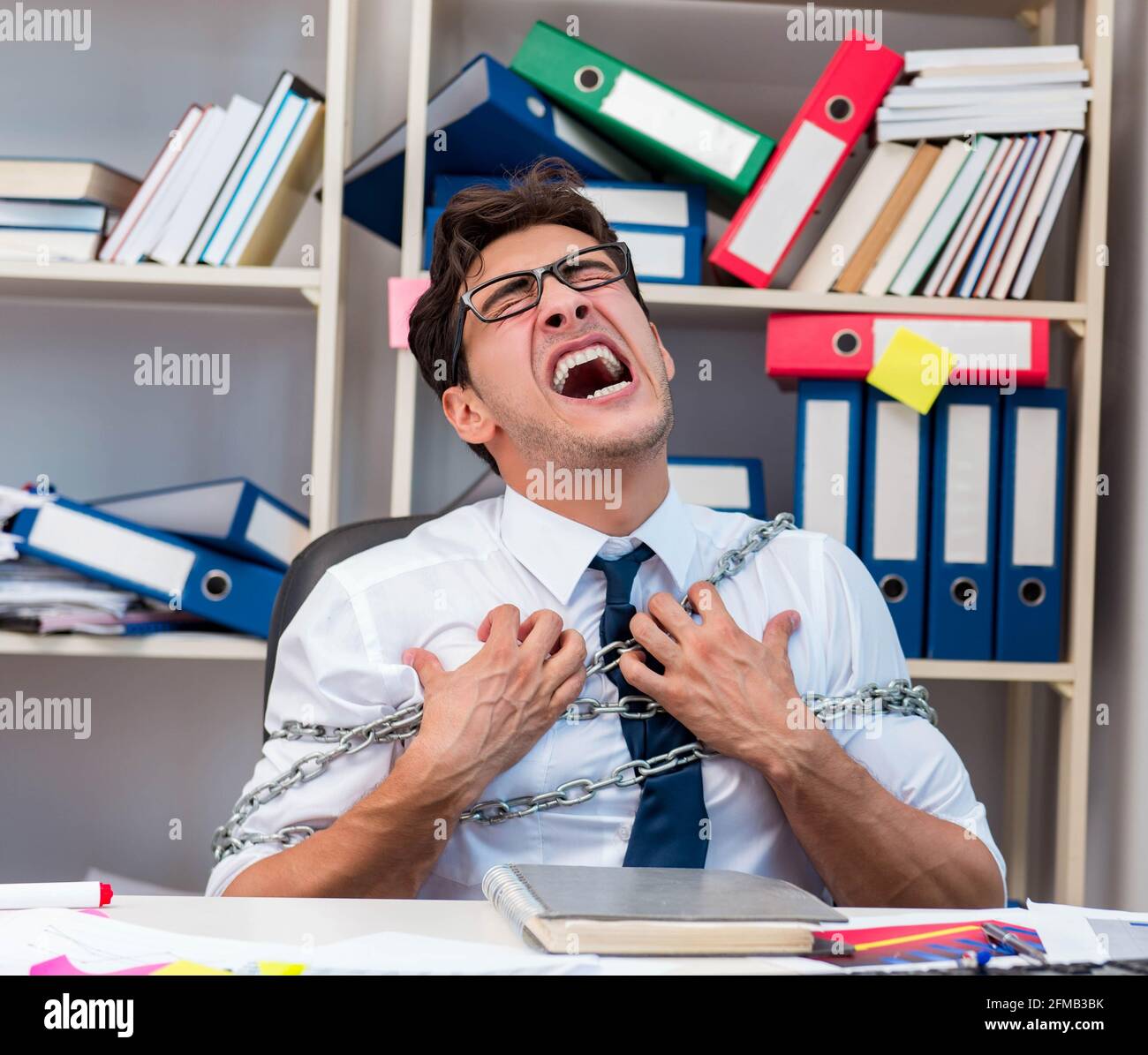 The employee attached and chained to his desk with chain Stock Photo ...