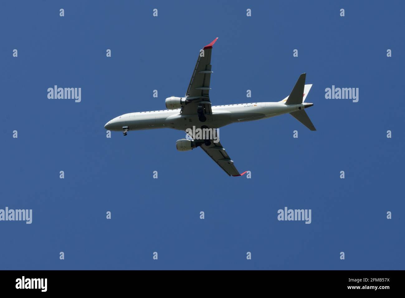 Low angle shot of a plane flying under the sunlight and a blue sky ...