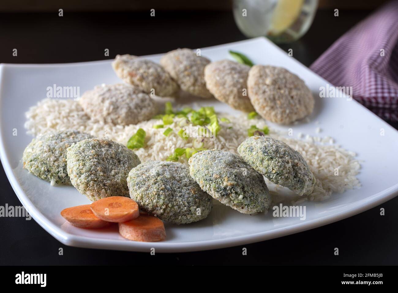Closeup of rice and vegetable nuggets on a square white plate Stock ...
