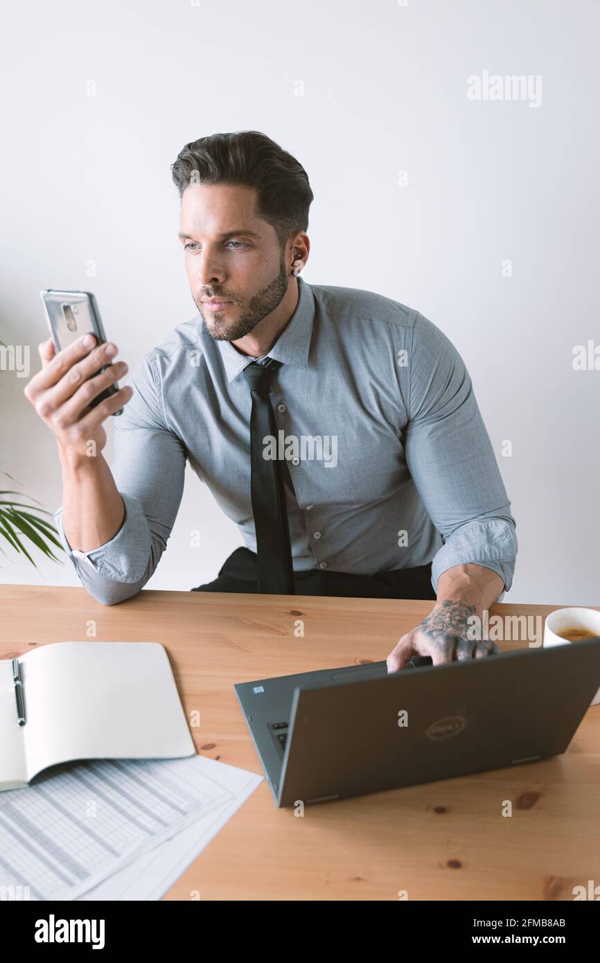 Vertical shot of a young businessman talking on a video call at the ...
