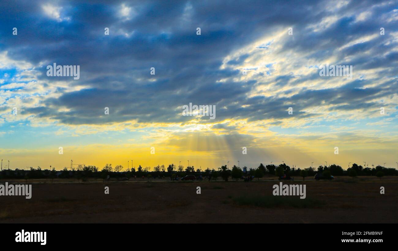 Natural yellow sunbeams in a very cloudy sky Stock Photo - Alamy