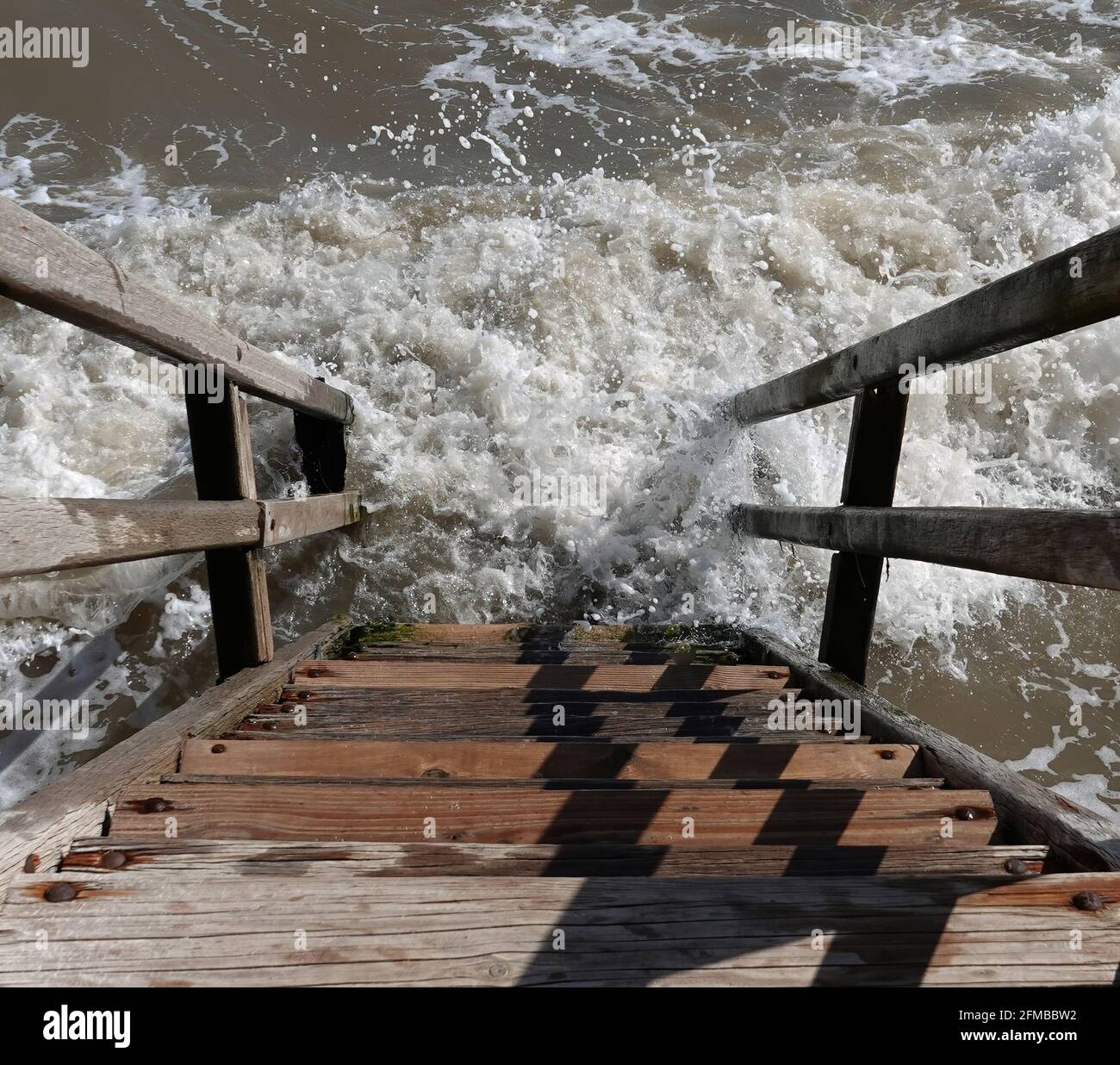 Flight of wooden stairs going down with angry sea waves in the bottom ...