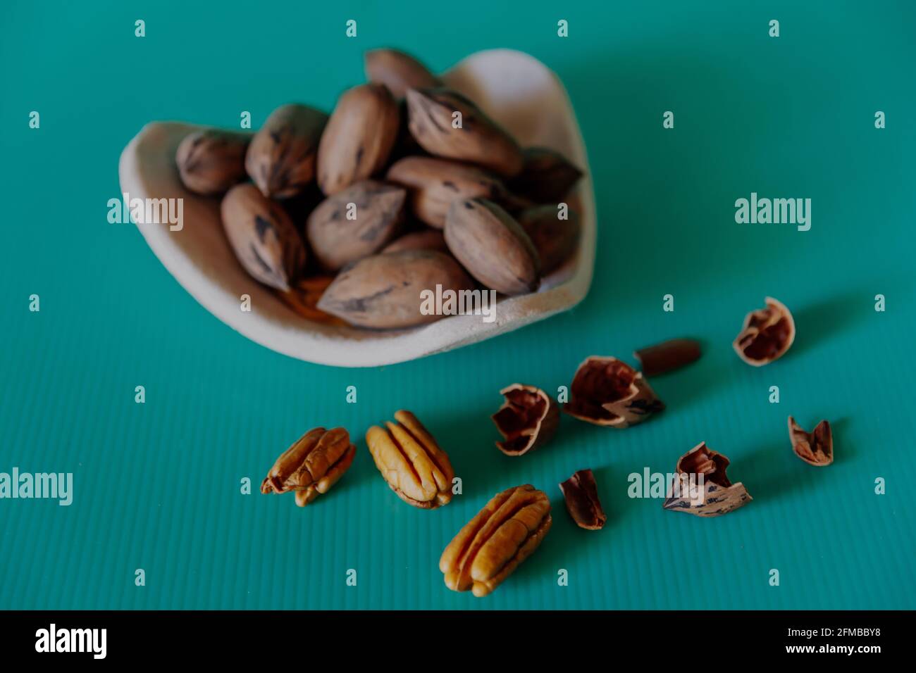Closeup shot of whole and shelled pecans on a green surface Stock Photo ...