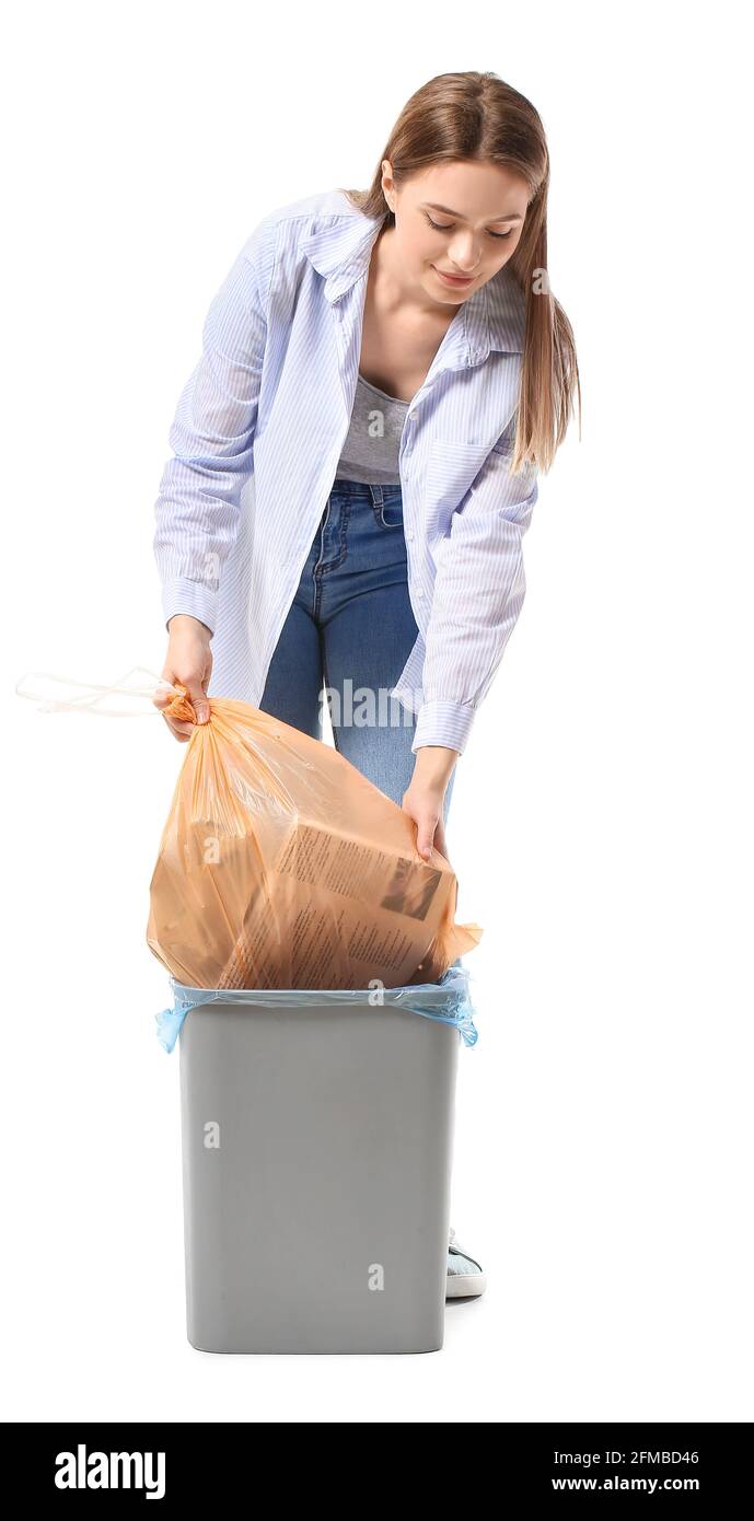 Young woman putting garbage in trash bin on white background Stock ...