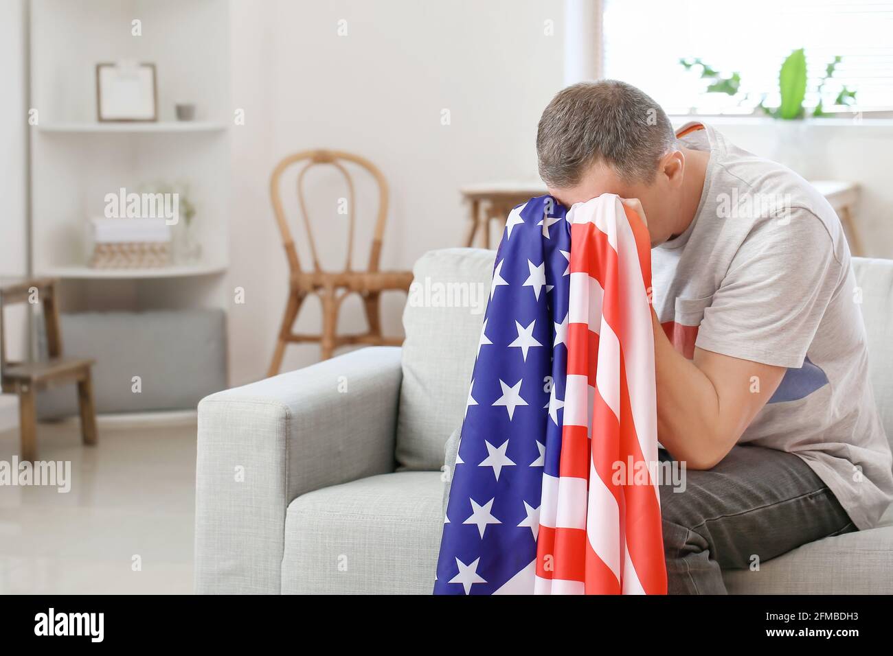 Sad man with USA flag at home. Memorial Day celebration Stock Photo - Alamy