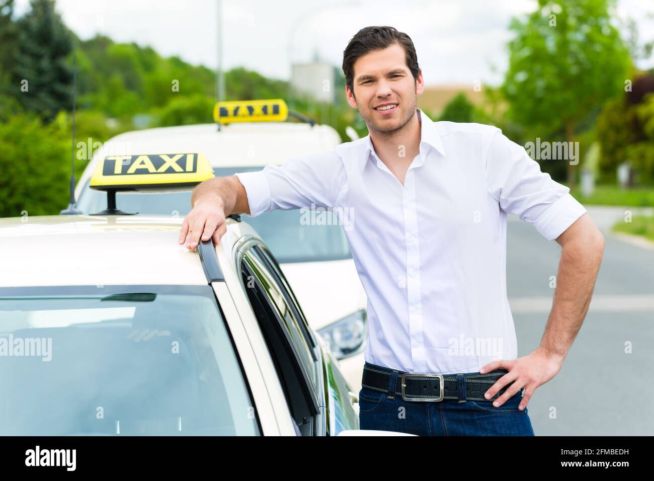 Experienced taxi driver in front of his taxi, waiting for a passenger ...