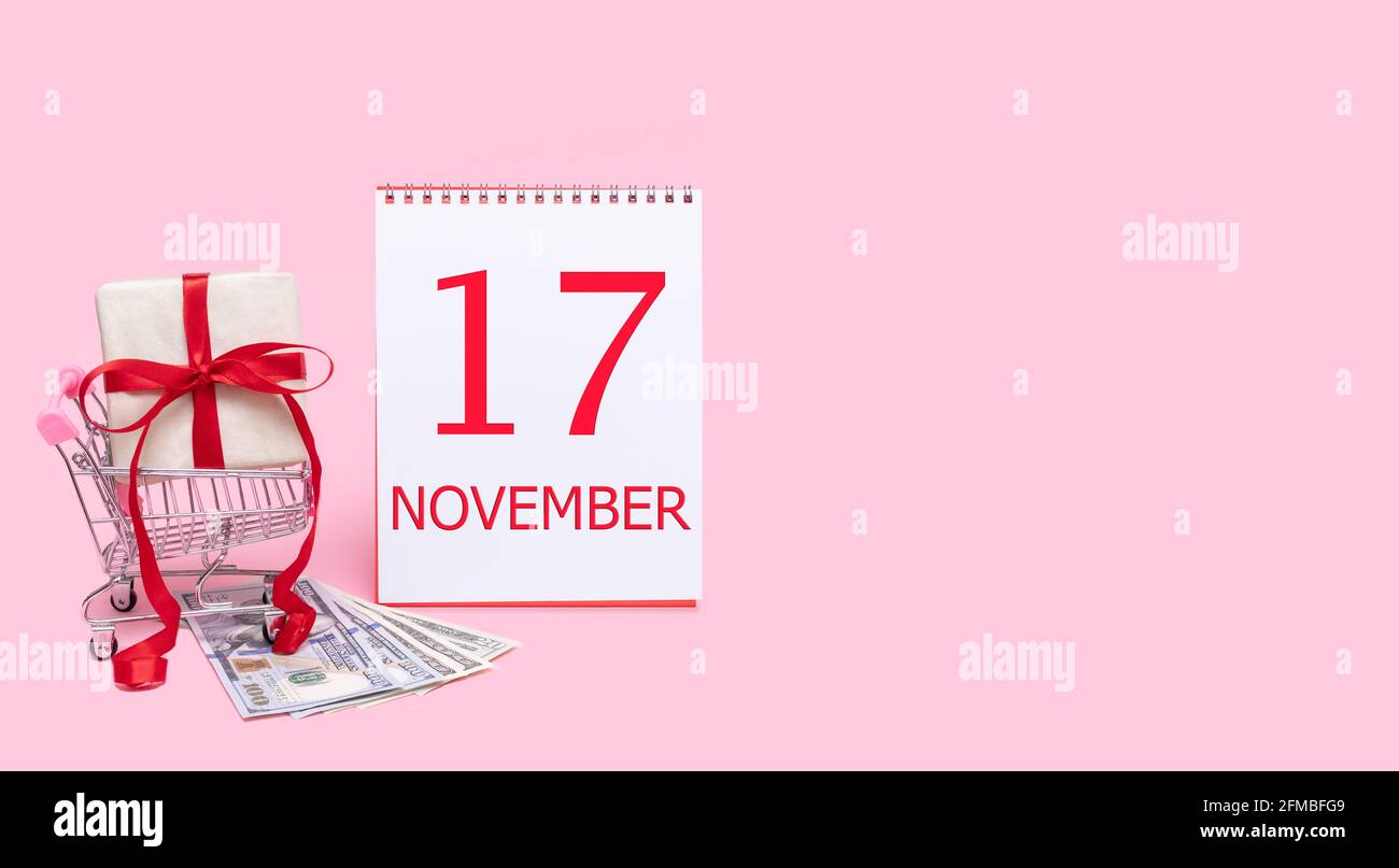 17th day of november. A gift box in a shopping trolley, dollars and a ...