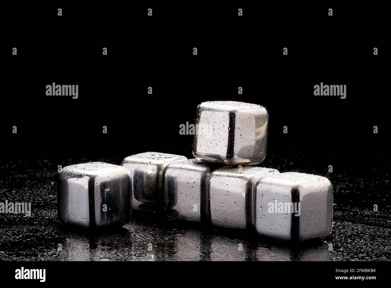 Steel cooling cubes for cocktail drink on glass background Stock Photo ...