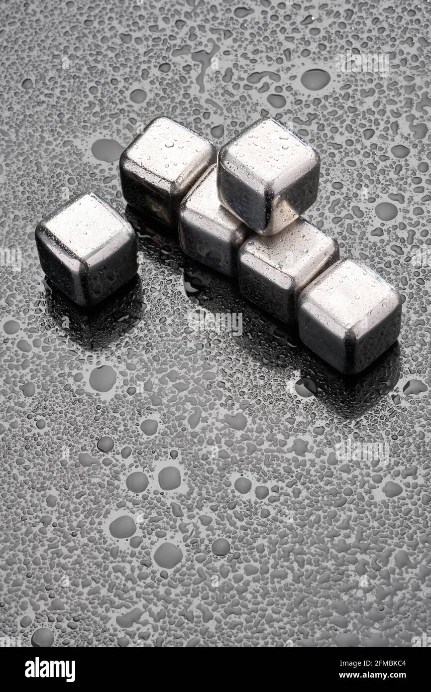 Steel cooling cubes for cocktail drink on glass background Stock Photo ...