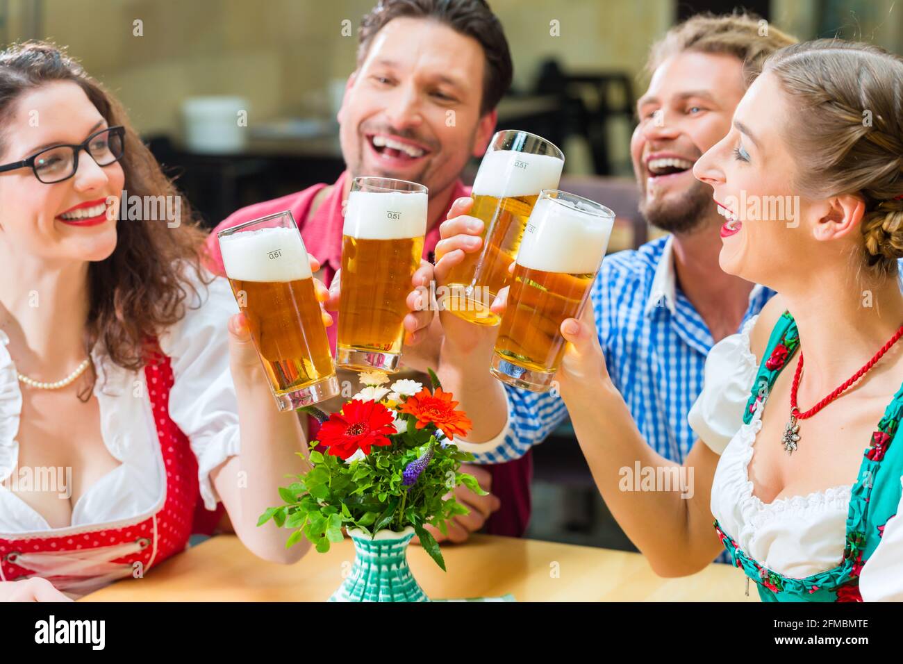 Friends in traditional Bavarian Tracht in restaurant or pub drinking ...