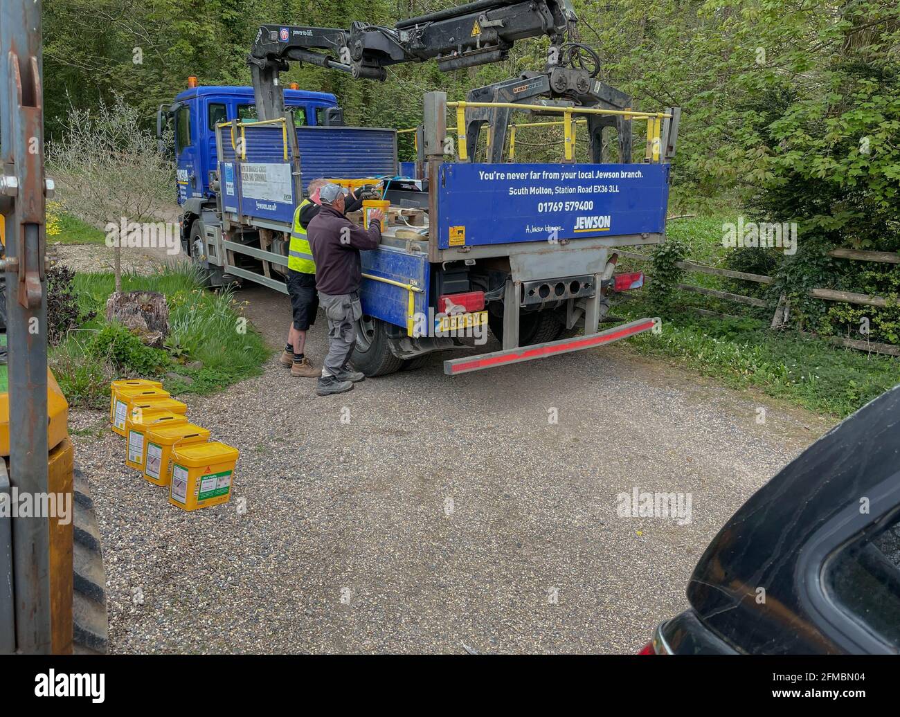 Workman and Lorry Driver Unloading Yellow Buckets of Grout from the ...