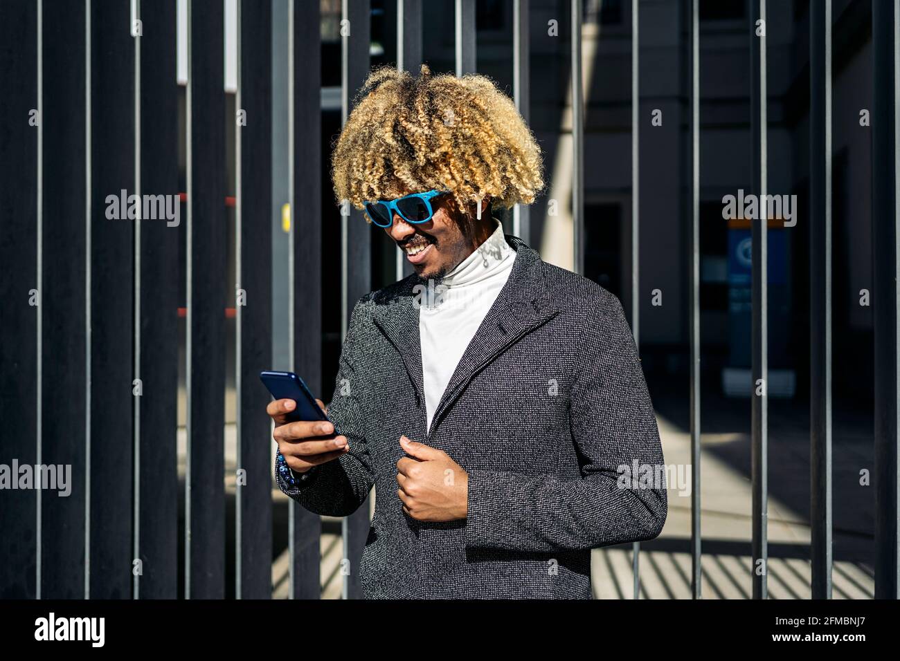 Handsome smart african man talking using a mobile phone at the street ...