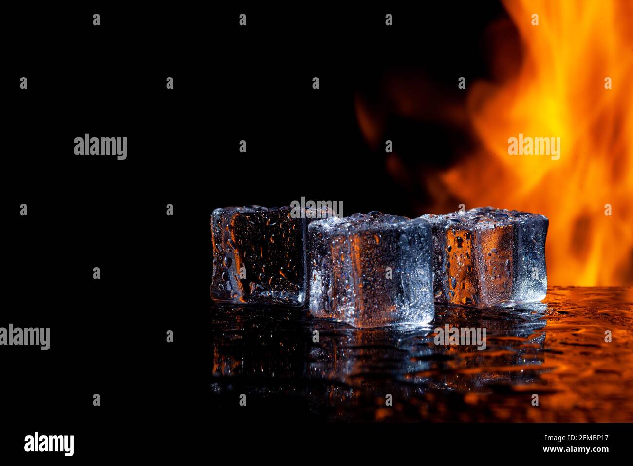 three ice cubes against the background of fire, fire and ice, place ...
