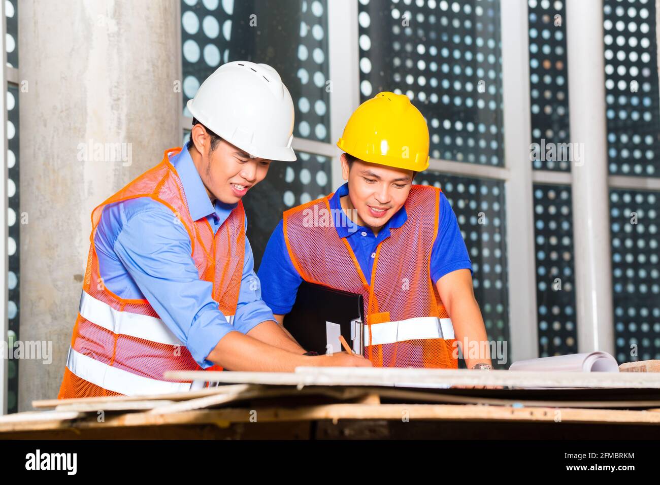 Chinese architect and supervisor point on building site on a ...