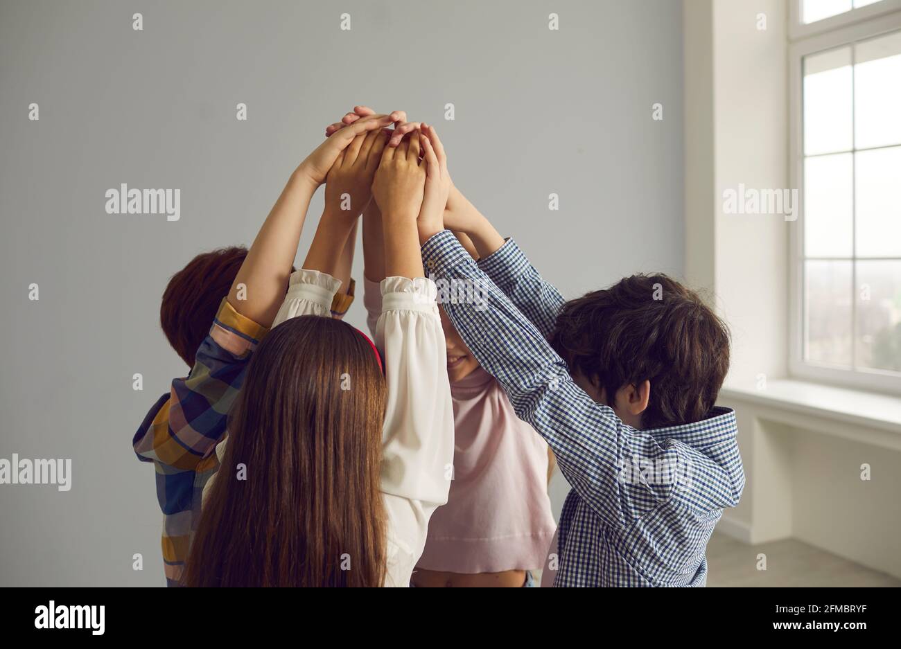 Team of little children standing close in circle and putting their ...