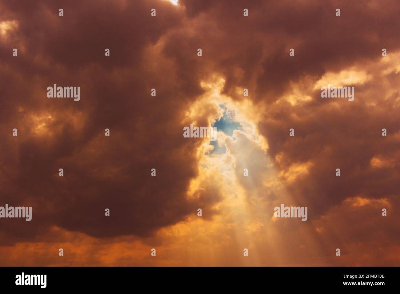 Cloudy orange sky with points of translucent sun rays Stock Photo - Alamy