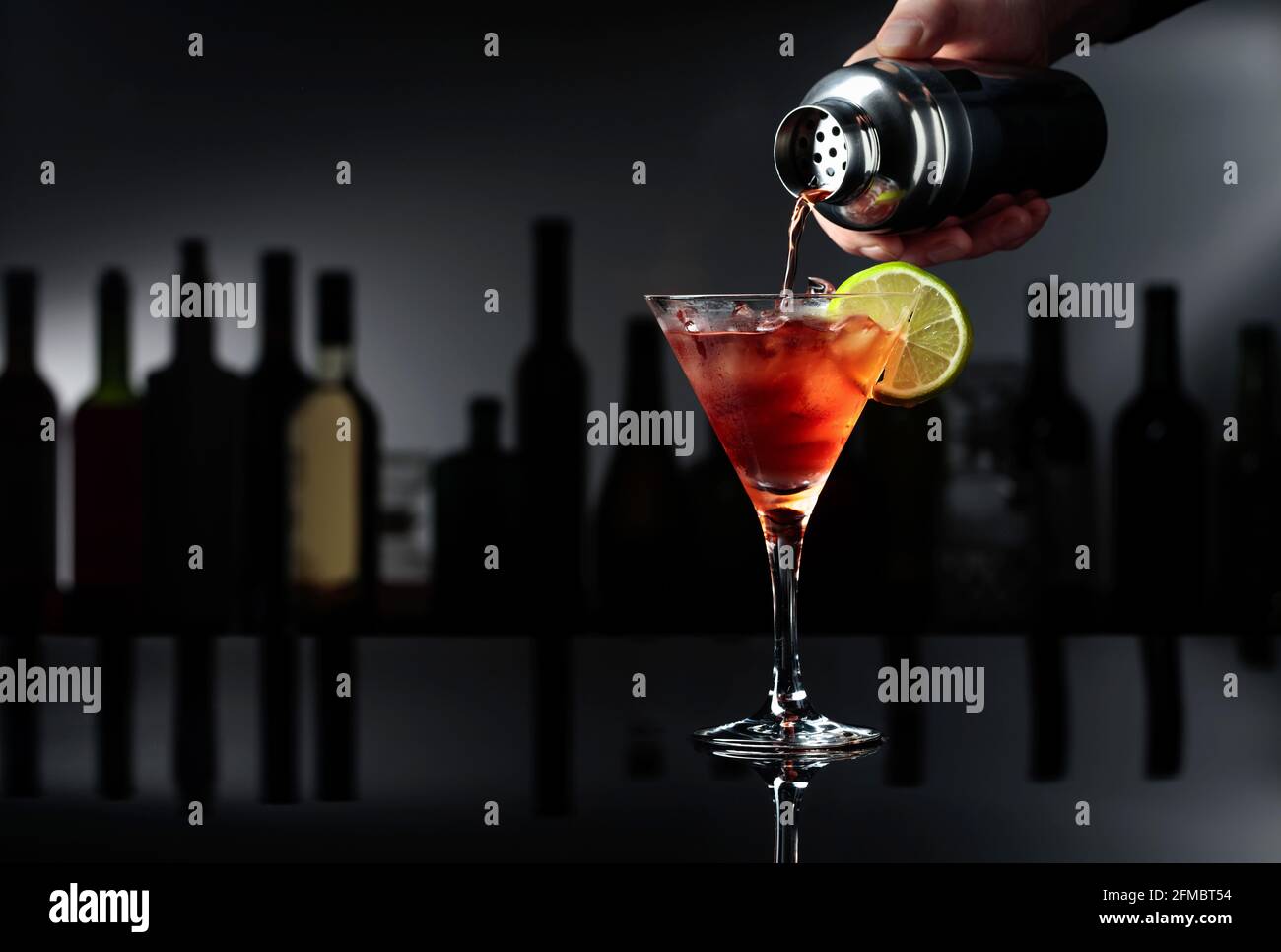 Cocktail "Barbados" on a black reflective background. The bartender ...