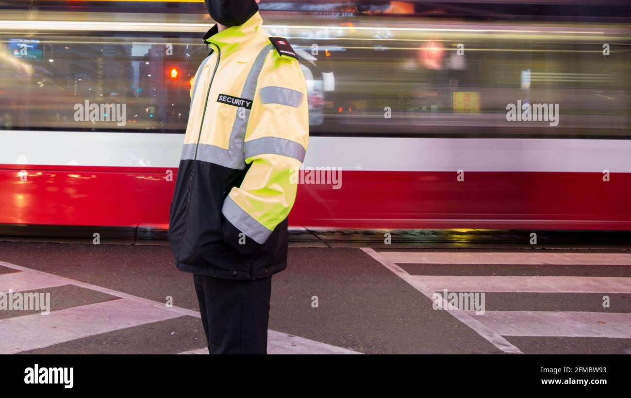 View of a security guard patrolling busy street and city before sunset ...