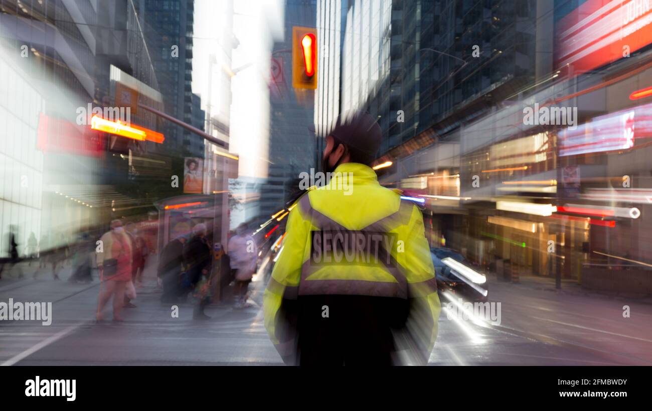 Traffic security guard in light green jacket patrolling street before ...