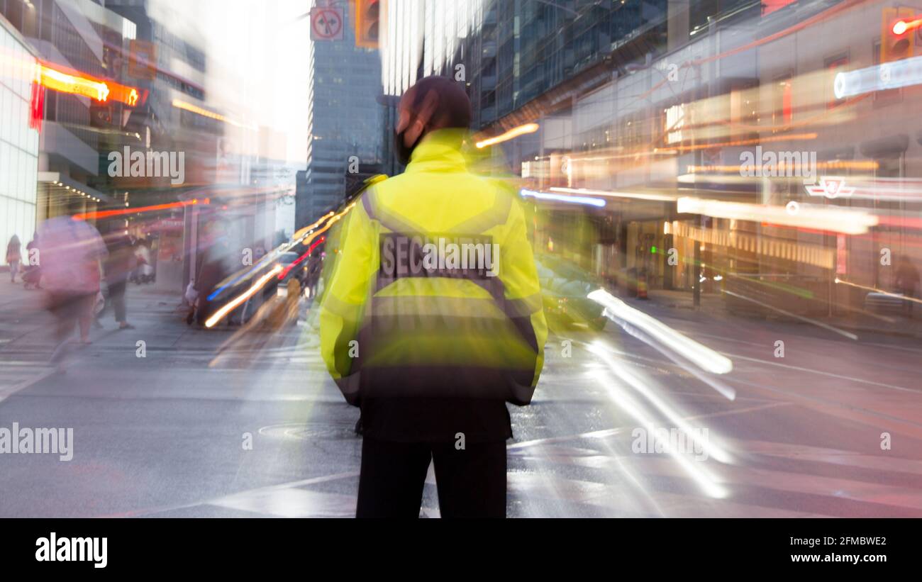 Traffic security guard in light green jacket patrolling street before ...