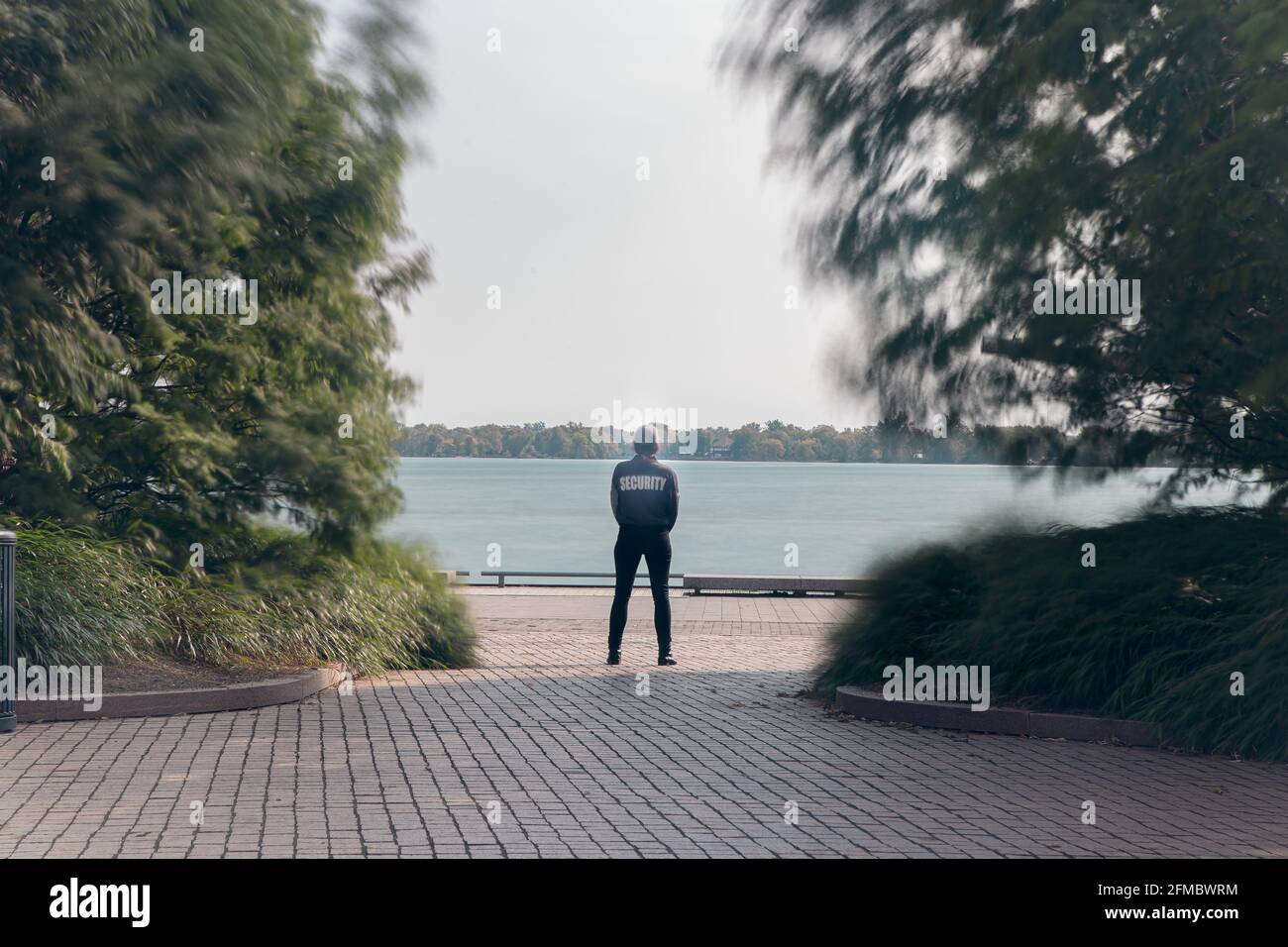 Female security guard in uniform and mask patrolling commercial area ...