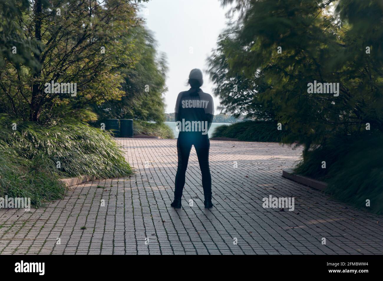 Female security guard in uniform and mask patrolling commercial area ...