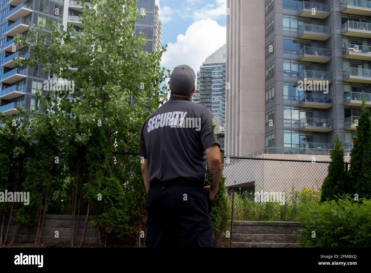 Tall security guard in a uniform patrolling condo area Stock Photo - Alamy