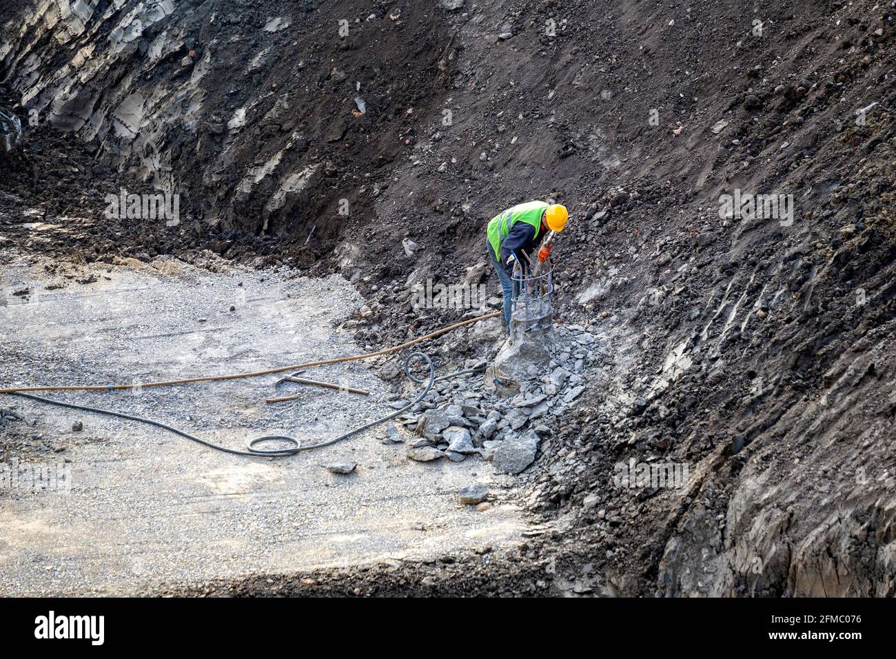 Construction worker breaking concrete reinforced pillar at construction ...