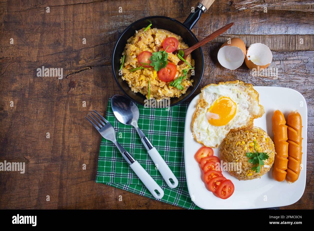 Cook American fried rice in a pan, served with fried eggs and sausages ...